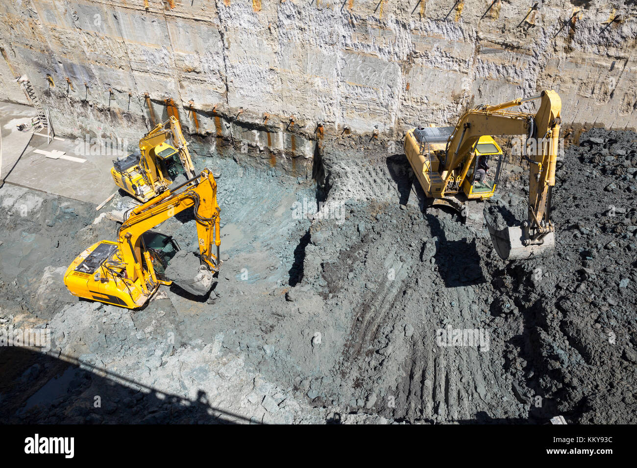 Excavators dig at a construction site of a street and a subway. Baggers ...