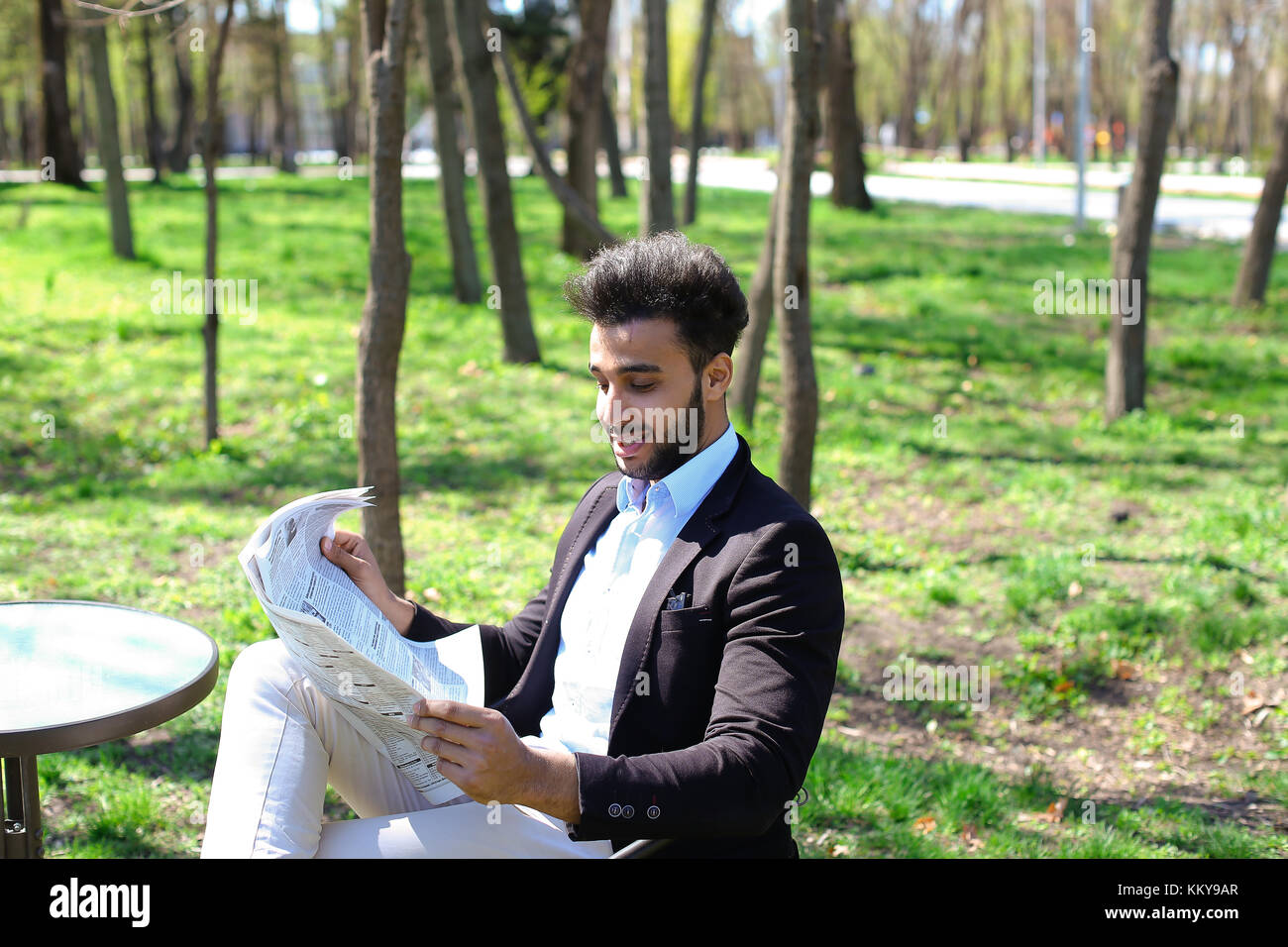 Business person reading newspaper and smiling with dimples on face ...