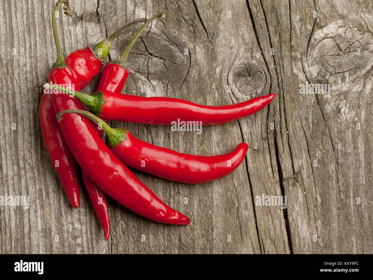 Red hot chili peppers on old wooden table Stock Photo - Alamy
