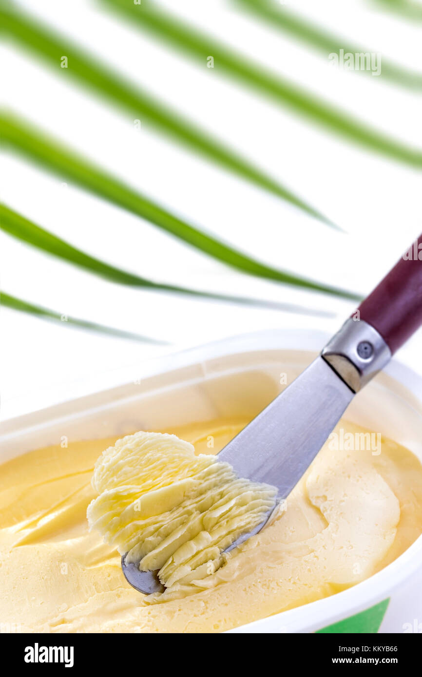 Butter curl with knife on white background and palm tree branch Stock ...