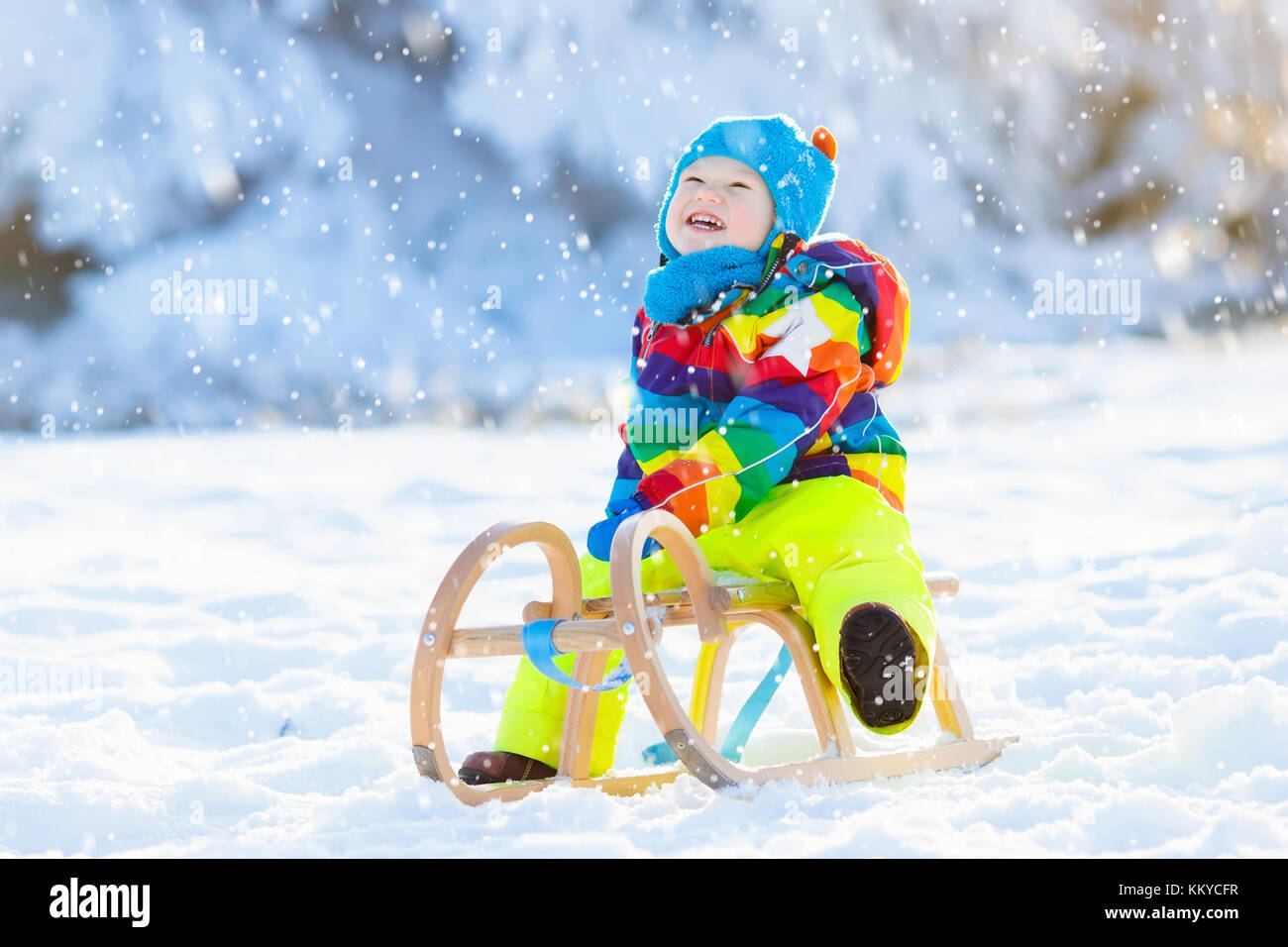 Little boy enjoying a sleigh ride. Child sledding. Toddler kid riding a ...