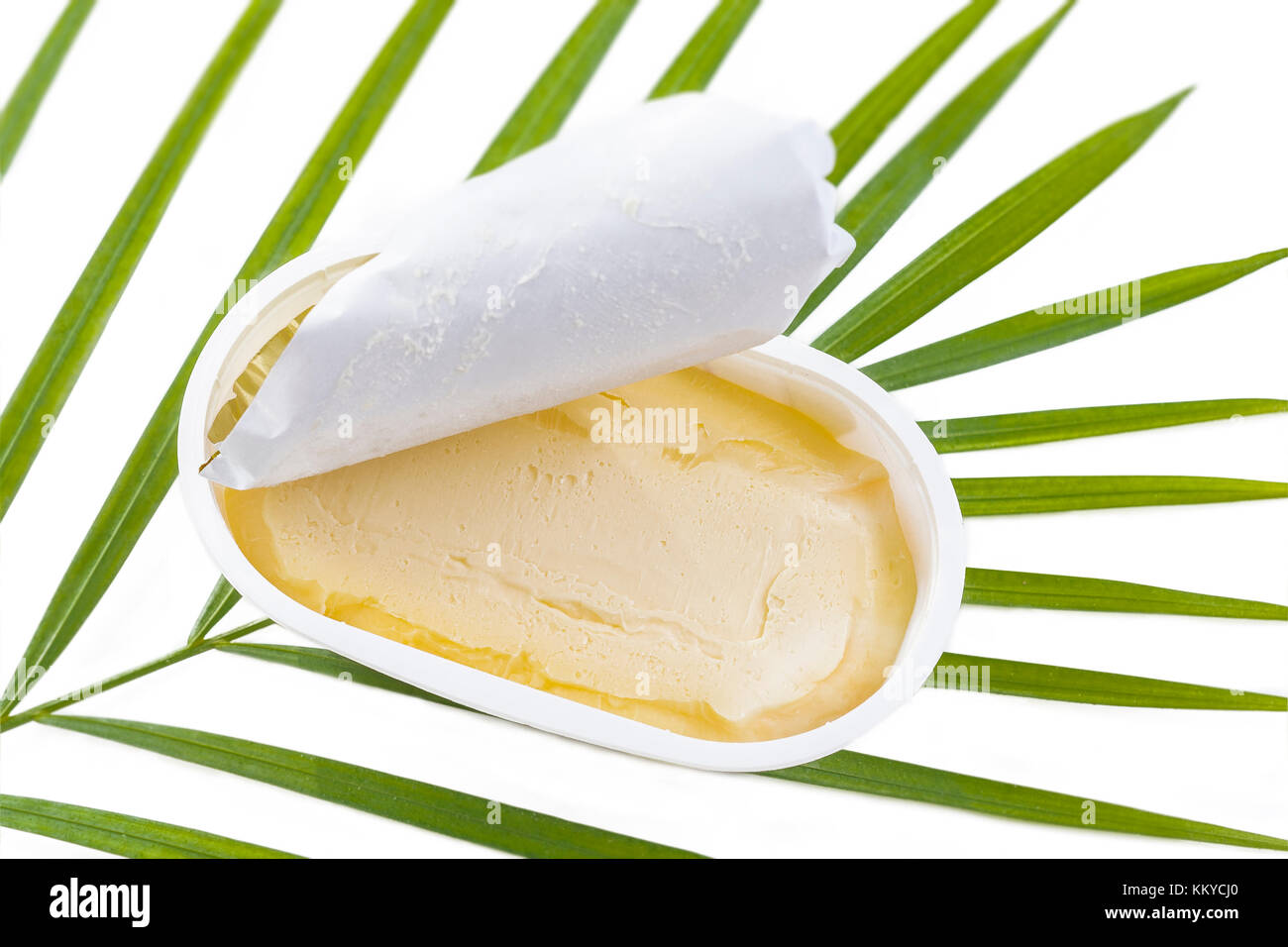 opened butter box on green pam leaf against a white background Stock ...