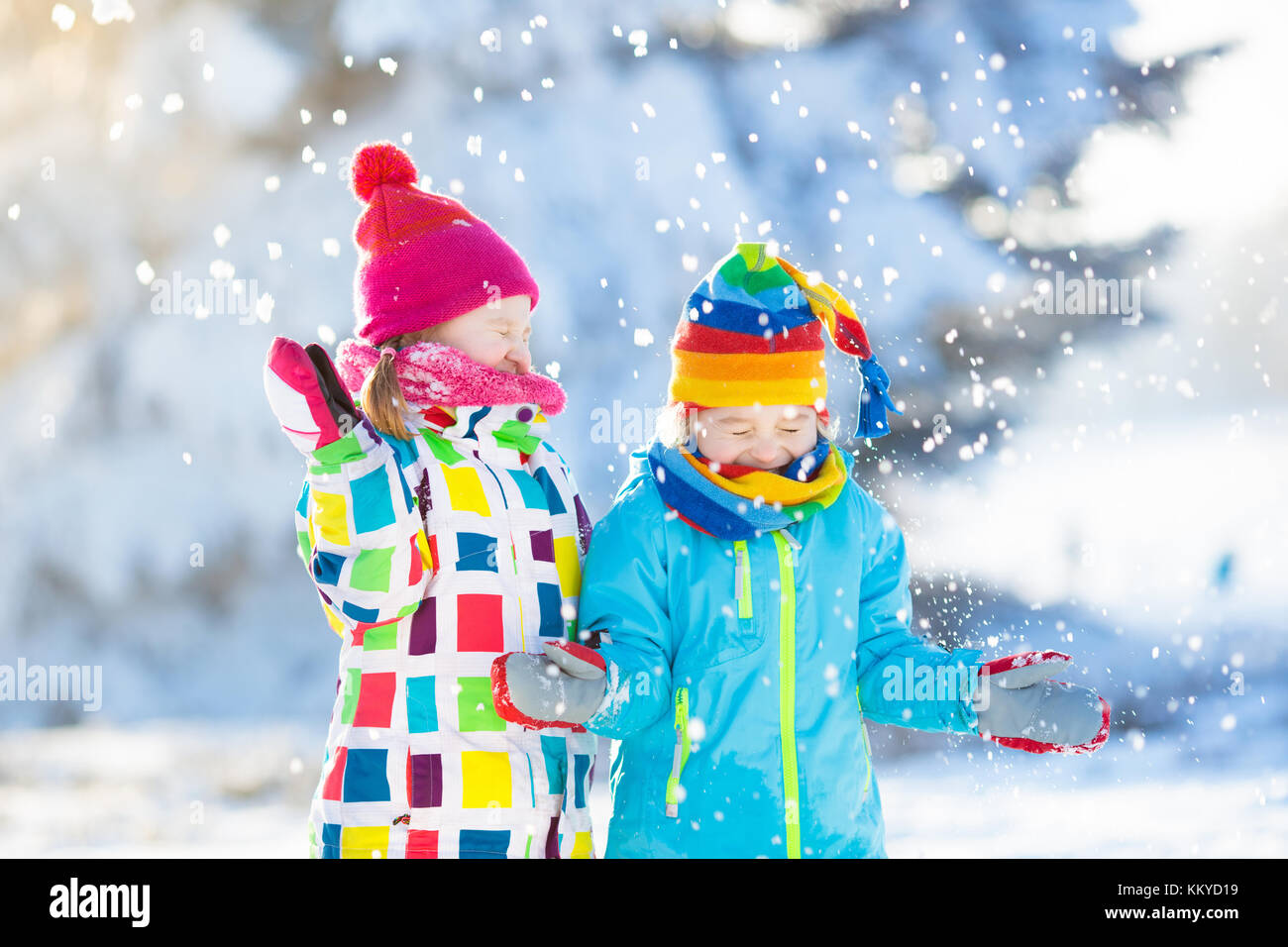 Kids playing in snow. Children play outdoors on snowy winter day. Boy ...