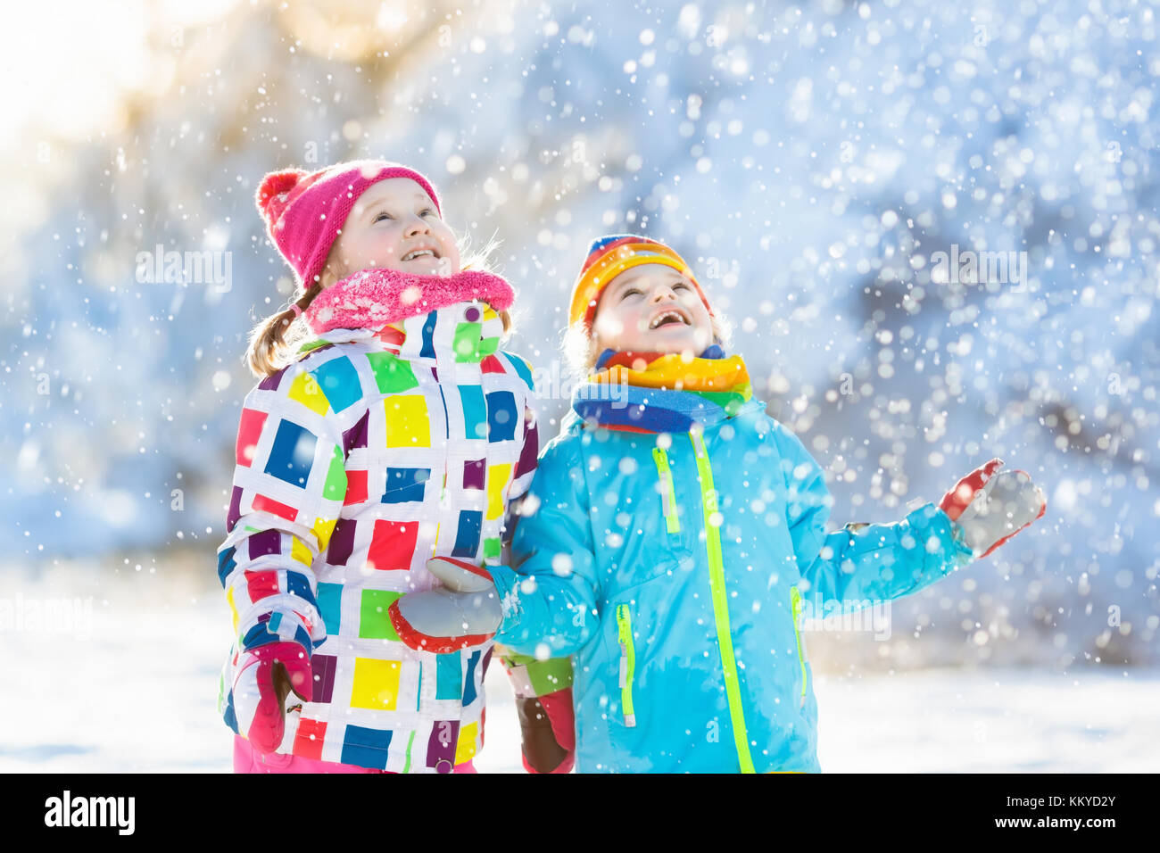 Kids playing in snow. Children play outdoors on snowy winter day. Boy ...