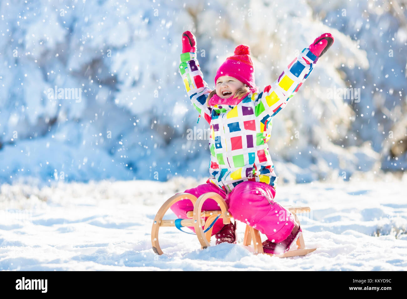 Little girl enjoying a sleigh ride. Child sledding. Toddler kid riding ...