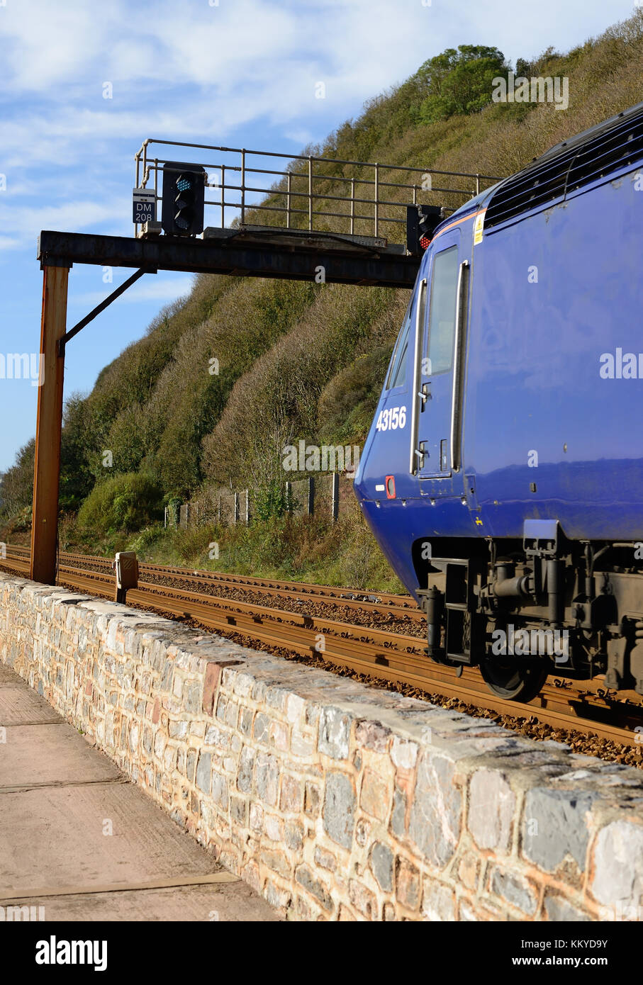 A high speed train passing a signal gantry along the sea wall at ...