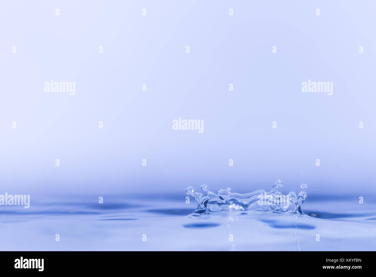 Close up of water drop dropping into water Stock Photo - Alamy