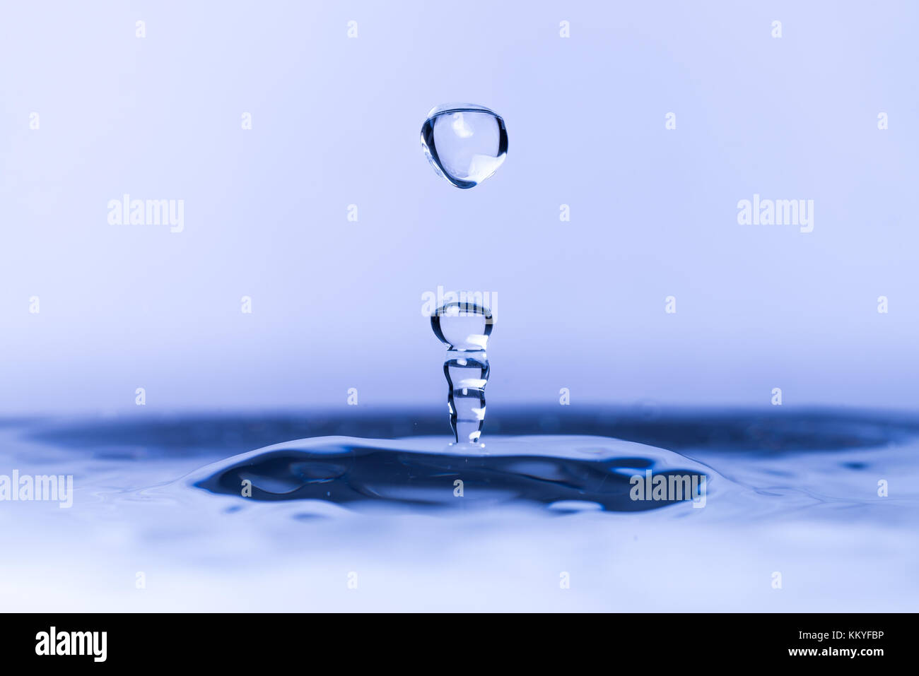 Close up of water drop dropping into water Stock Photo - Alamy