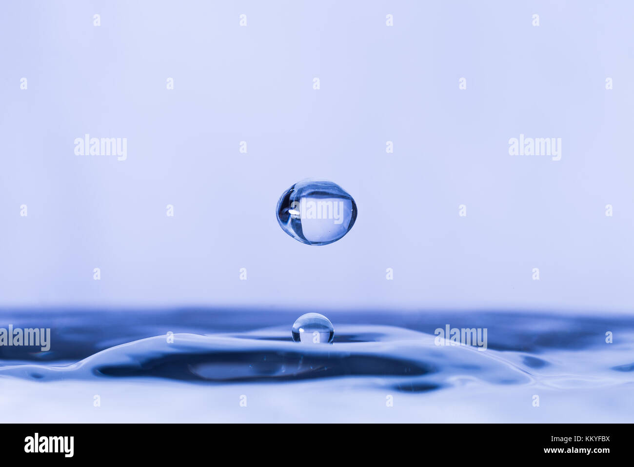 Close up of water drop dropping into water Stock Photo - Alamy