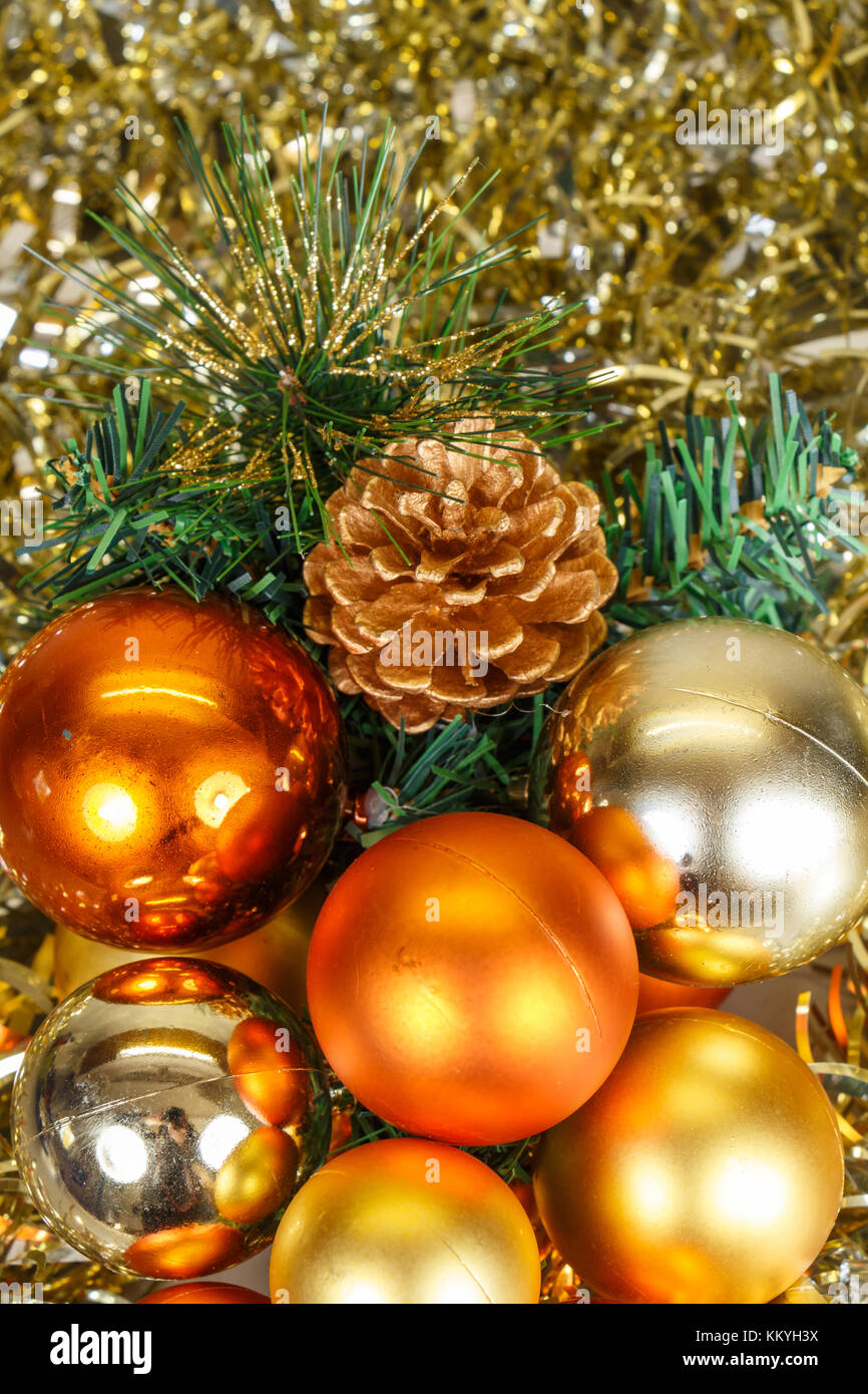 Orange baubles, golden tinsel and artificial fir tree branch as ...