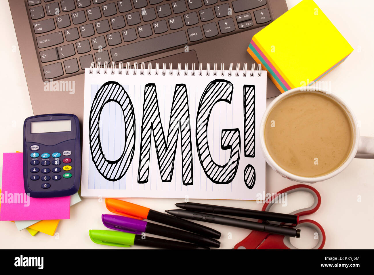 Word writing OMG Oh My God in the office with laptop, marker, pen ...