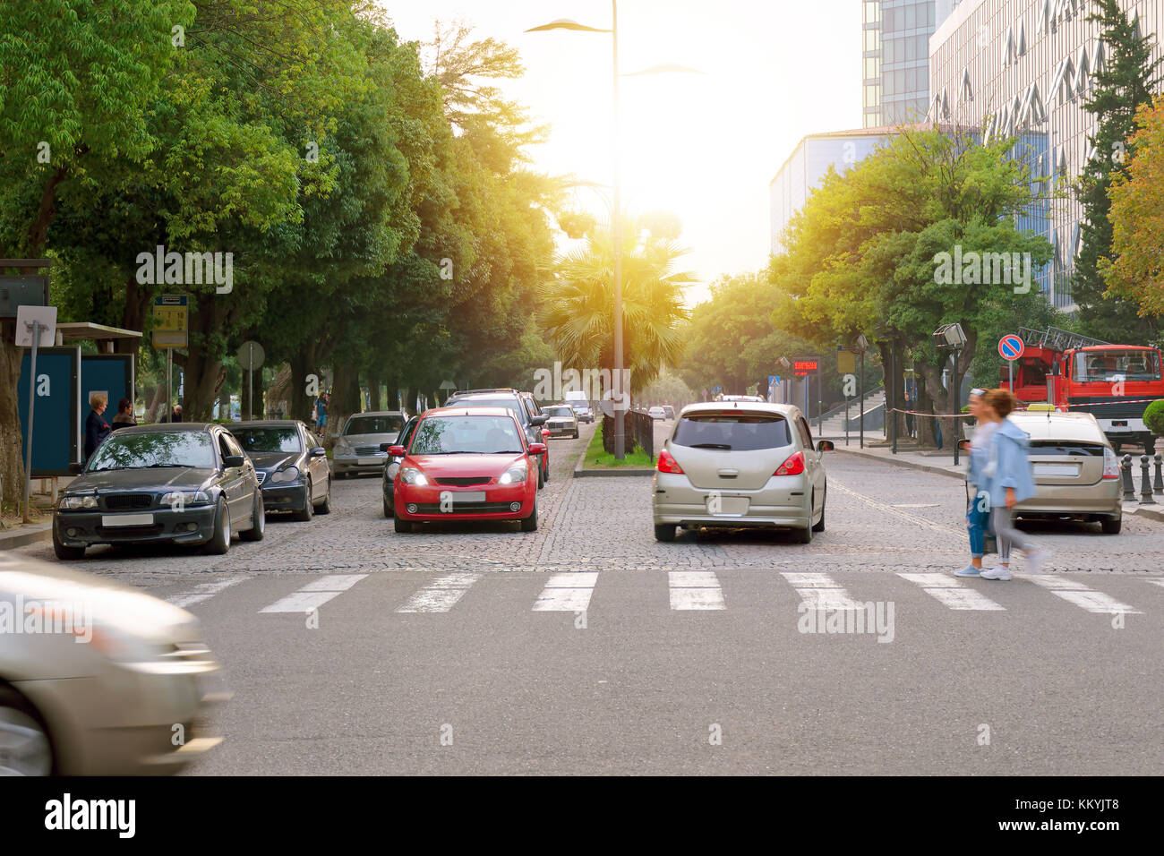 City life - road with a pedestrian crossing, cars and people Stock ...