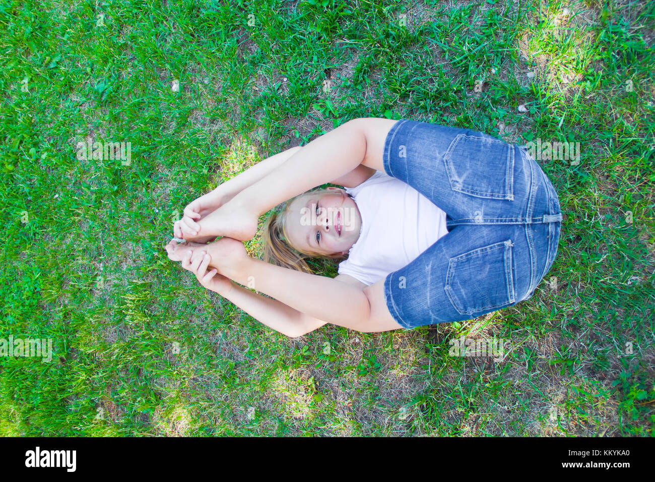 Cute girl playing legs upwards in summer Stock Photo - Alamy