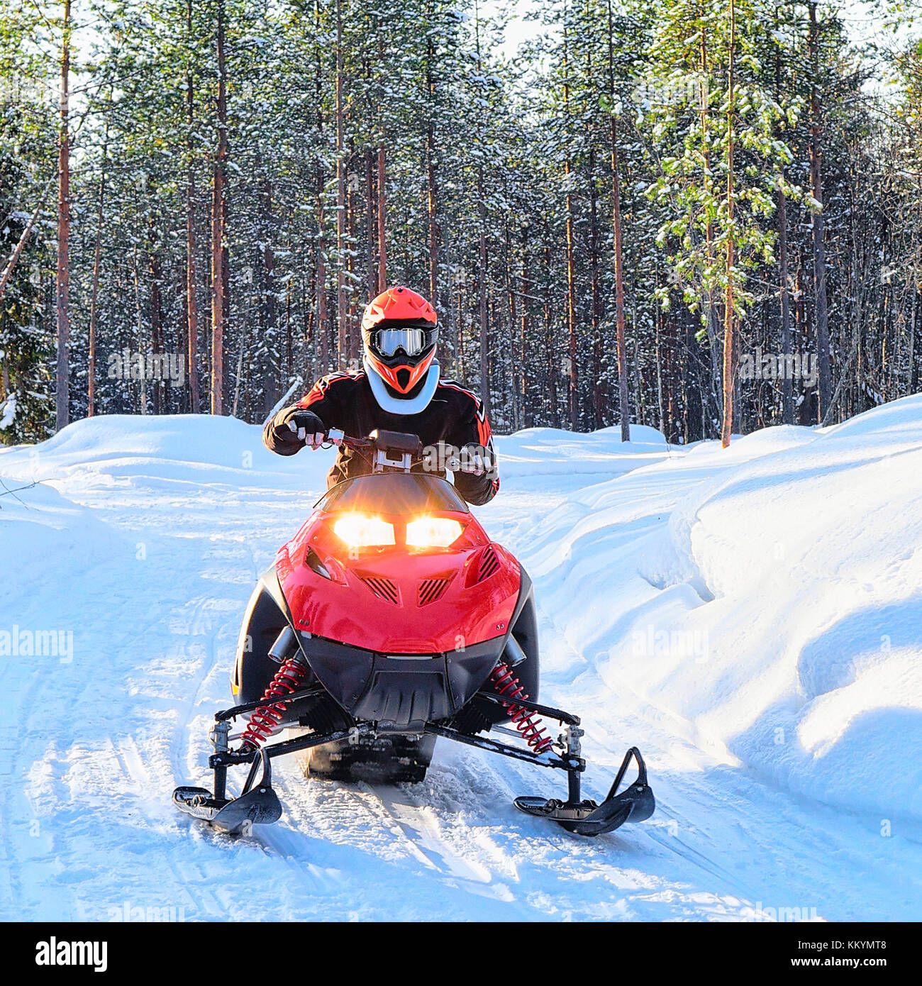 Woman riding red snowmobile on the frozen lake at winter Rovaniemi ...