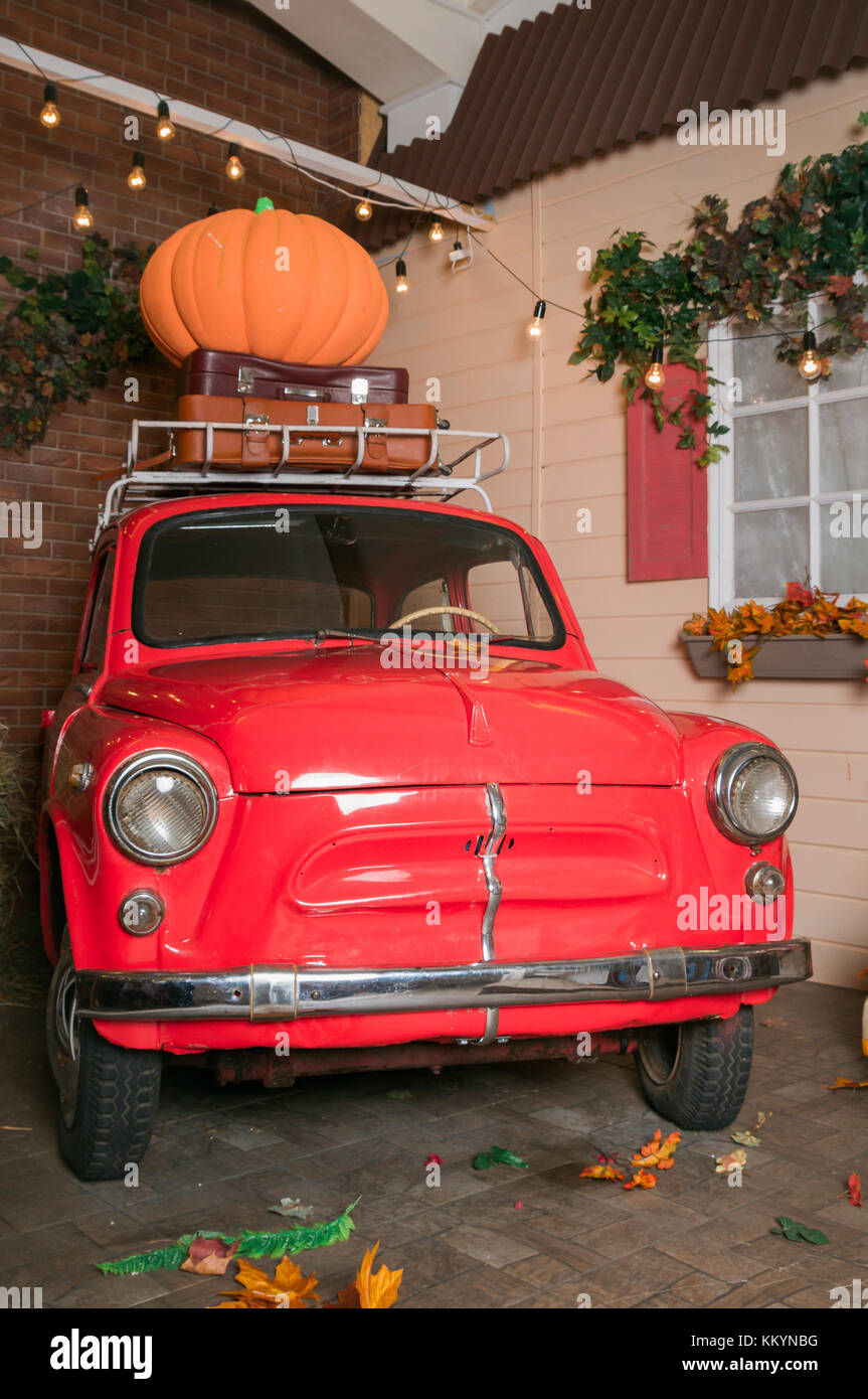 Retro red car on autumn scenery in front of the house Stock Photo - Alamy
