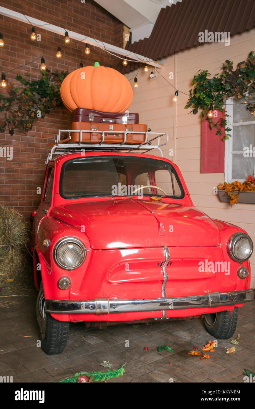Retro red car on autumn scenery in front of the house Stock Photo - Alamy