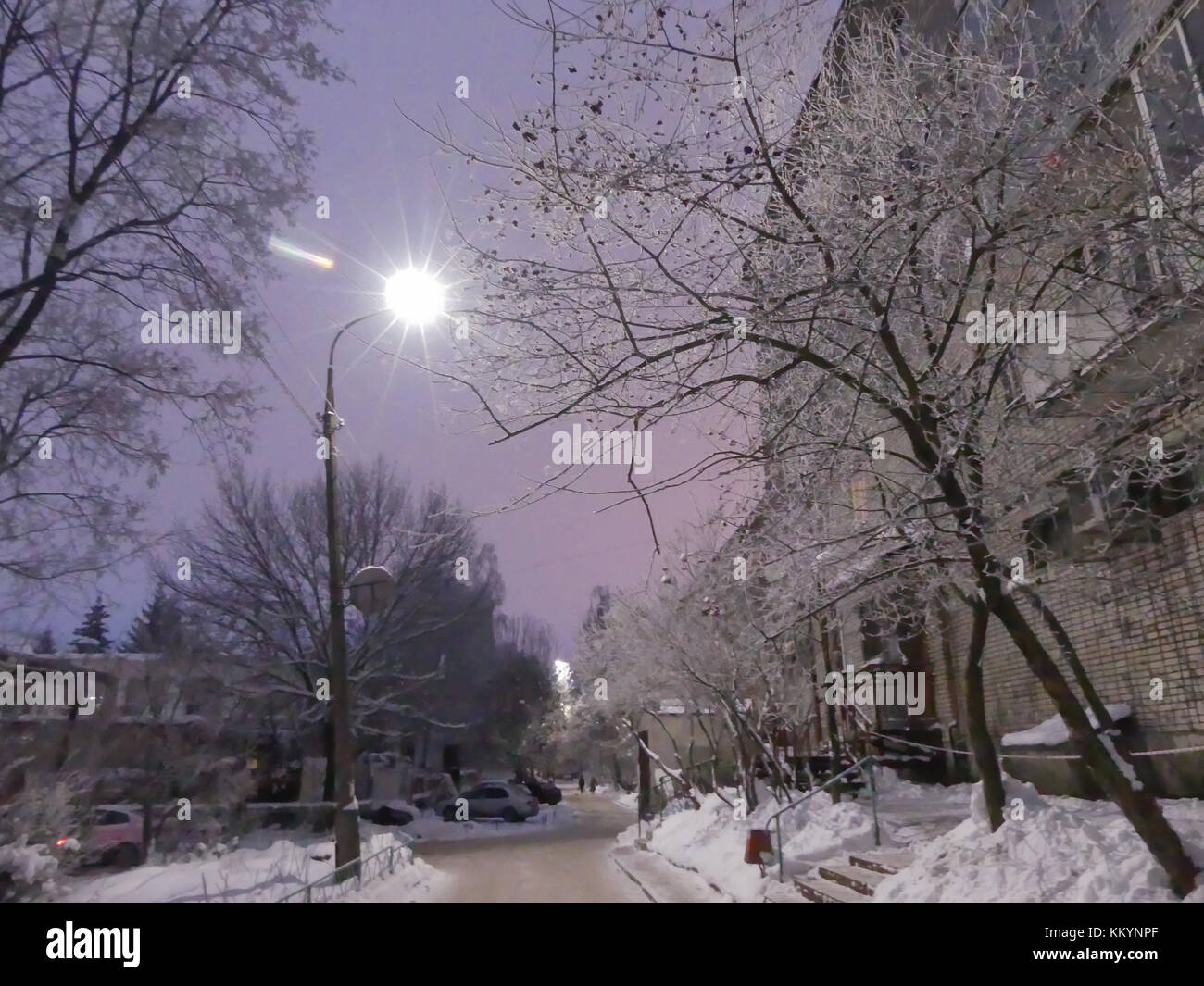 Empty city alley winter snow building lantern evening Stock Photo - Alamy