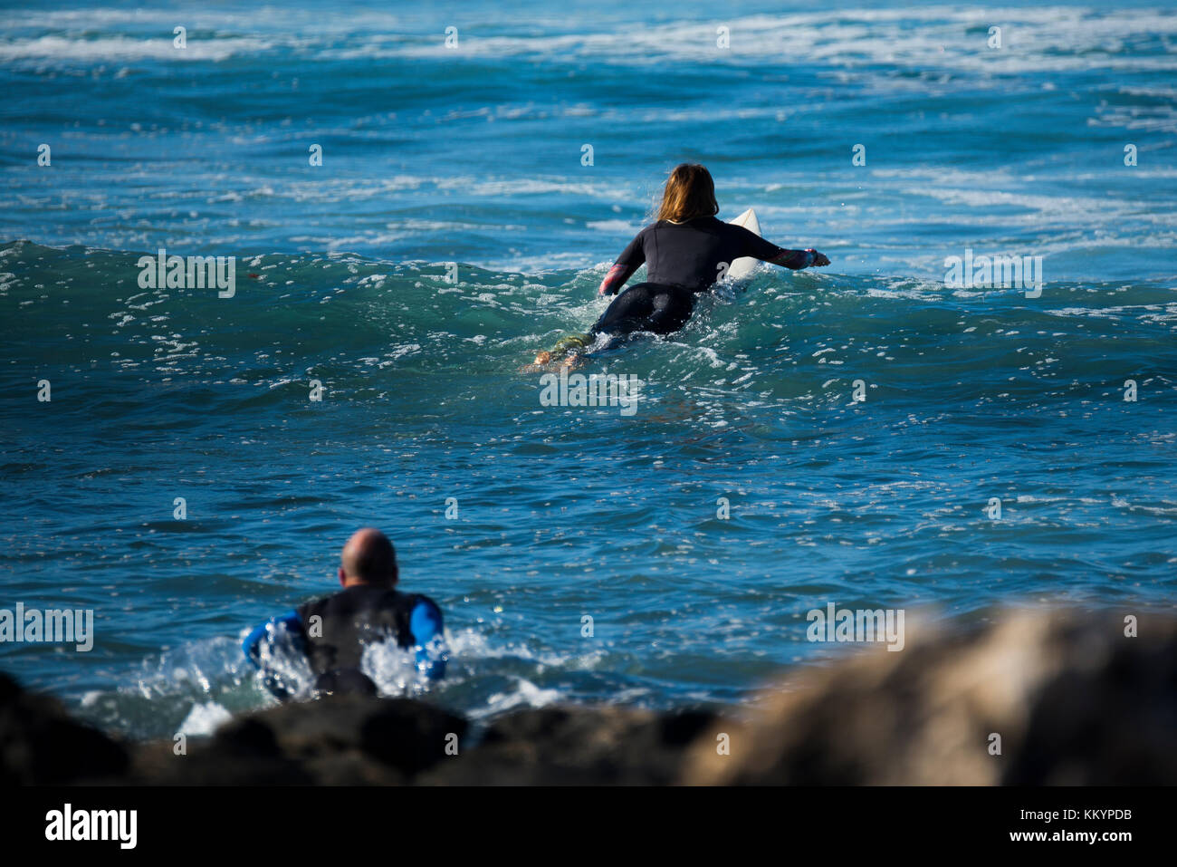 two surfers enter the water Stock Photo - Alamy