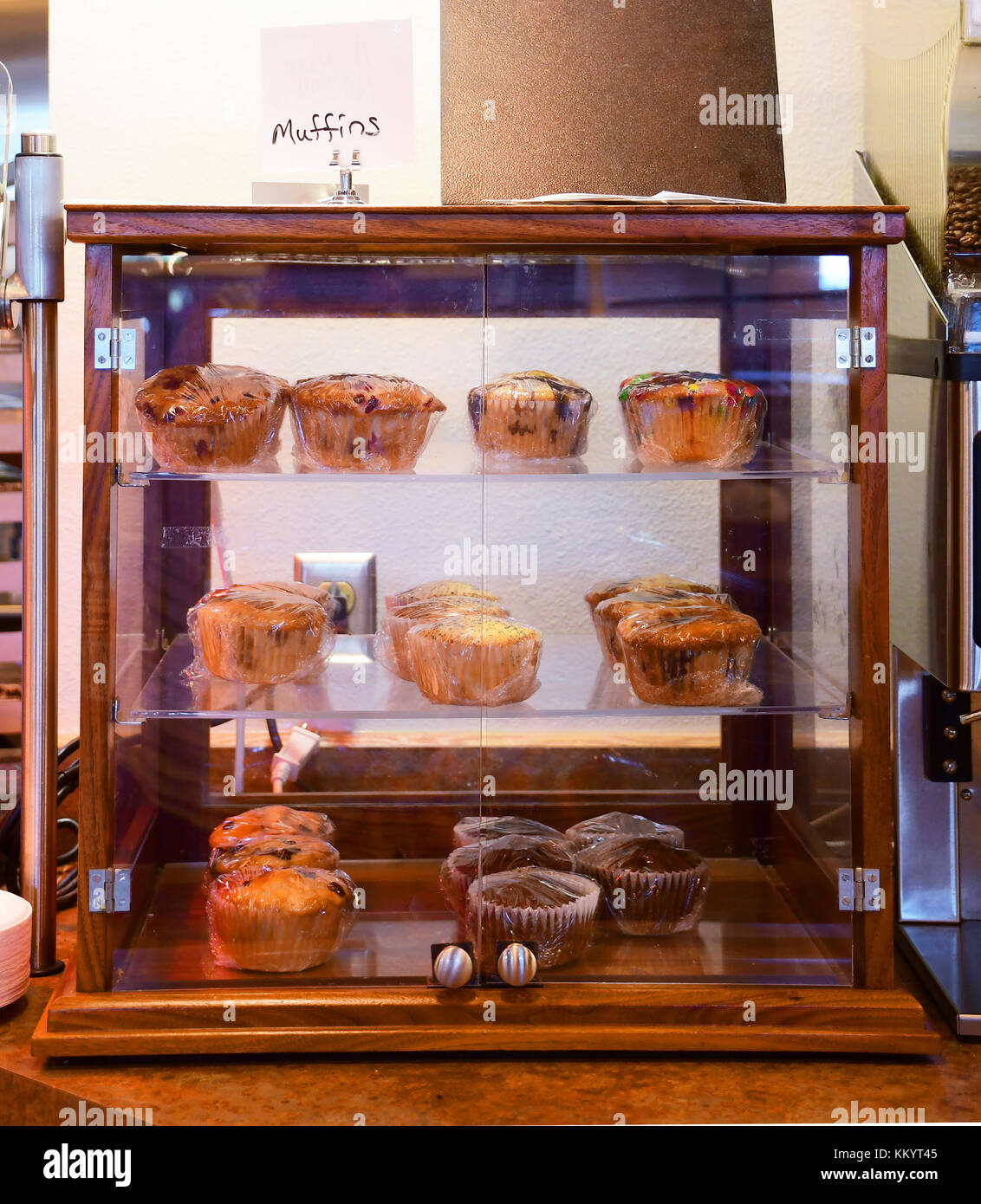 Variety of muffins in a glass display case at a cafeteria Stock Photo ...