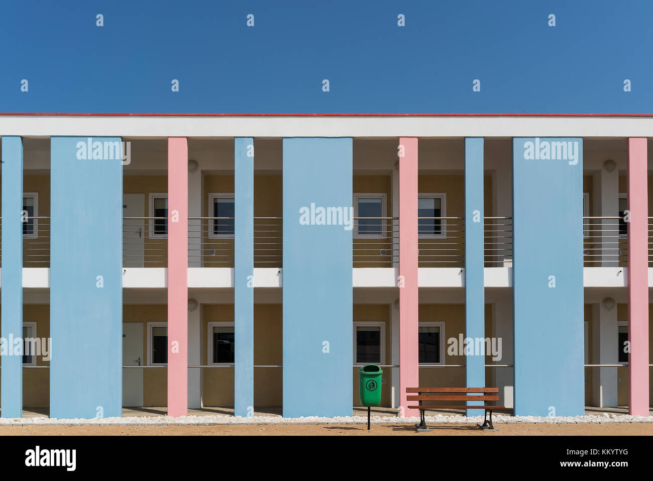 colorful building facade with bench and dustbin Stock Photo - Alamy