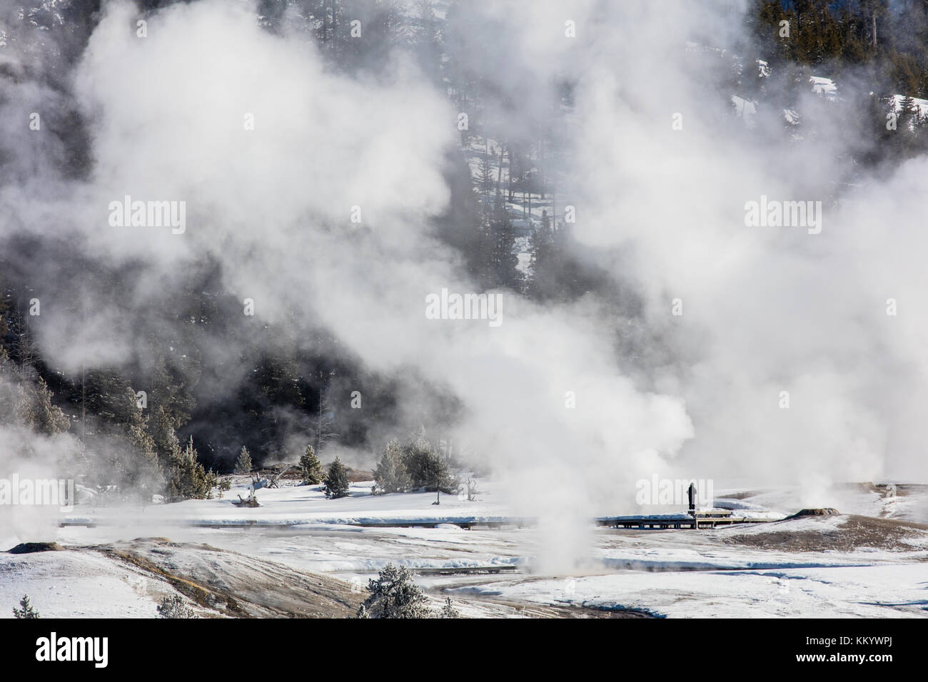 Snow and ice surround the Upper Geyser Basin in winter at the ...