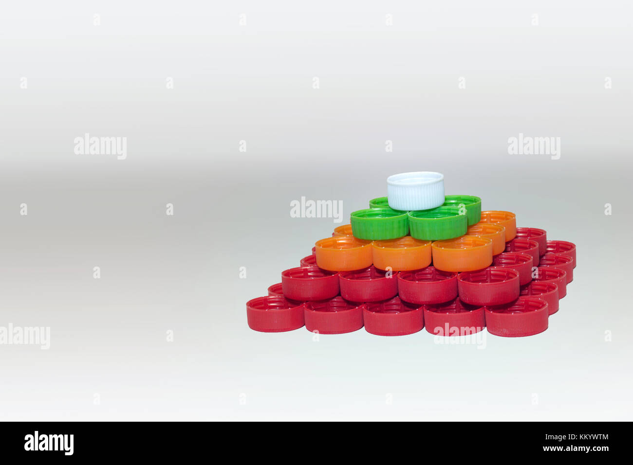 pyramid of whites, reds, greens, oranges striped caps of plastic ...