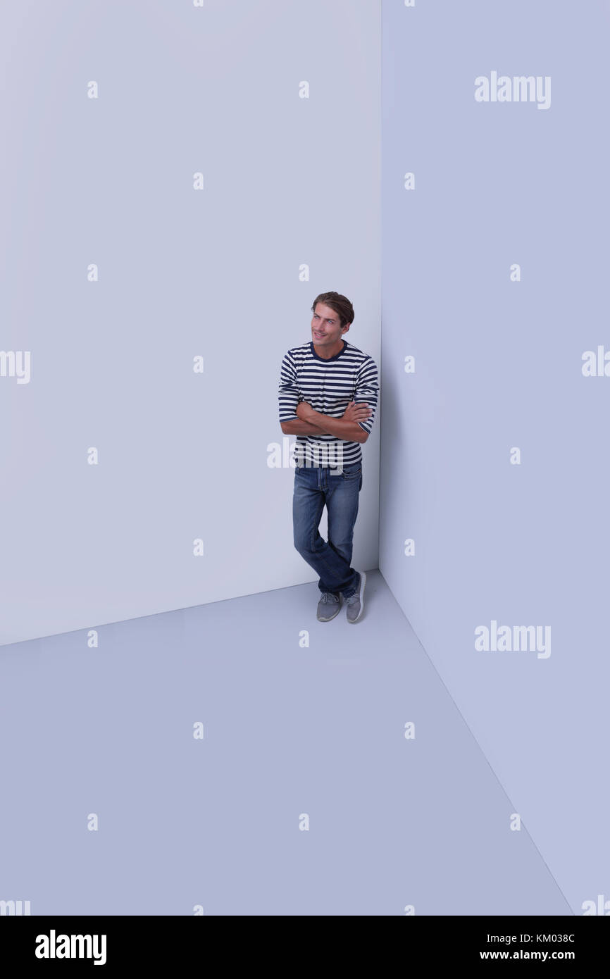 thoughtful man standing in the corner Stock Photo - Alamy