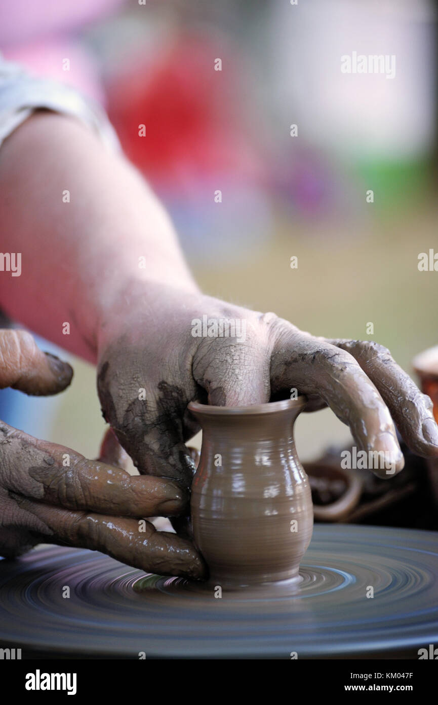 Traditional pottery making, close up of potter's hands shaping a bowl ...