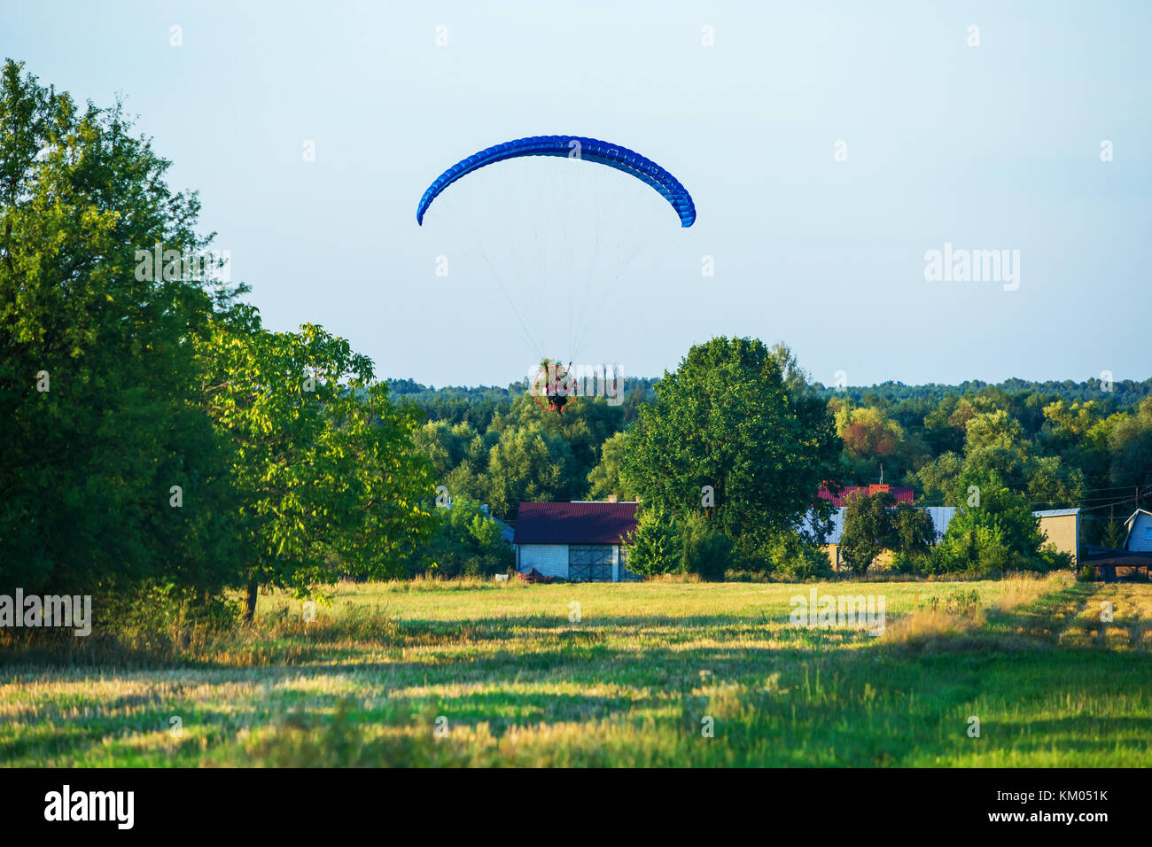 Paraglider flies with the parachute in the countryside of Poland Stock ...