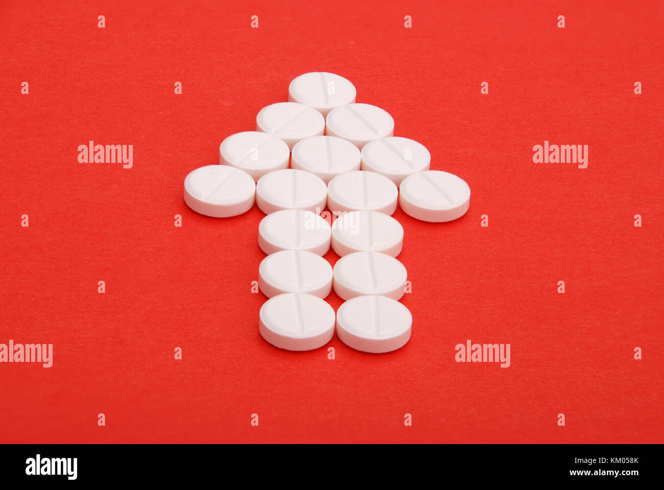 Arrow of Pills on red background Stock Photo - Alamy