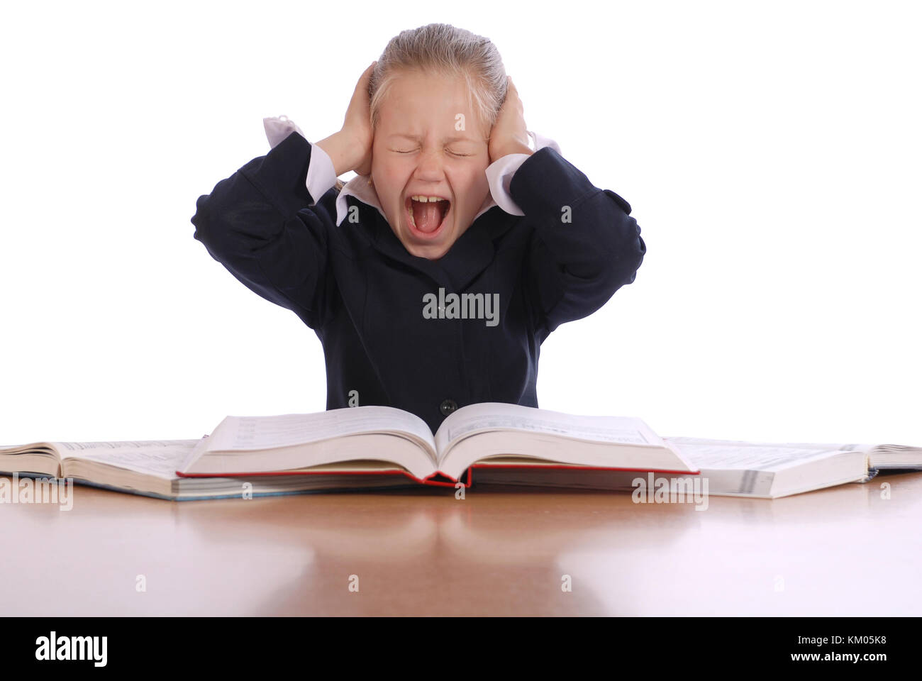 The girl shouts. Holds both hands a head. Near a table with books Stock ...