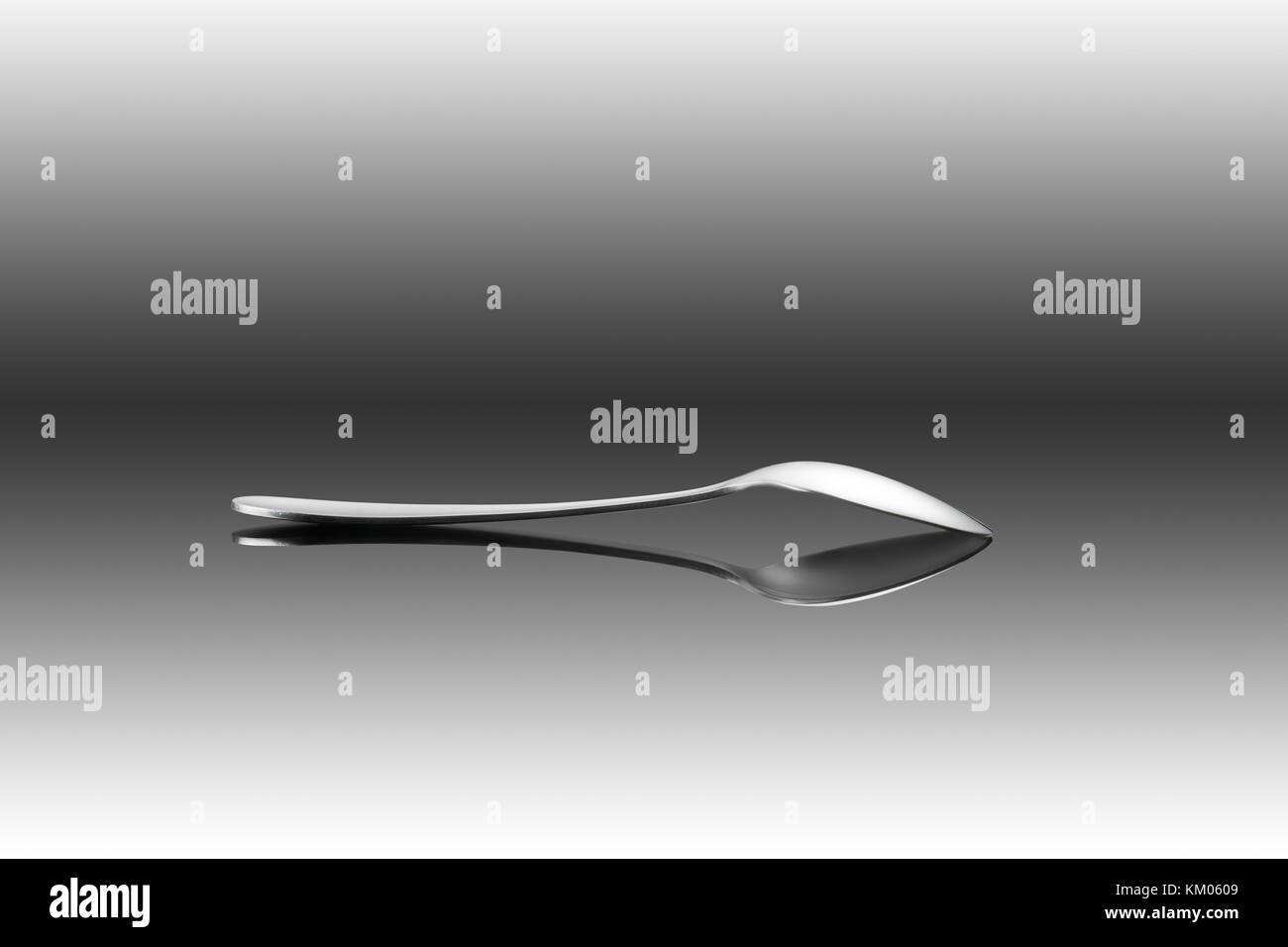 Tea spoon with reflection side view on gray gradient table. Isolated ...