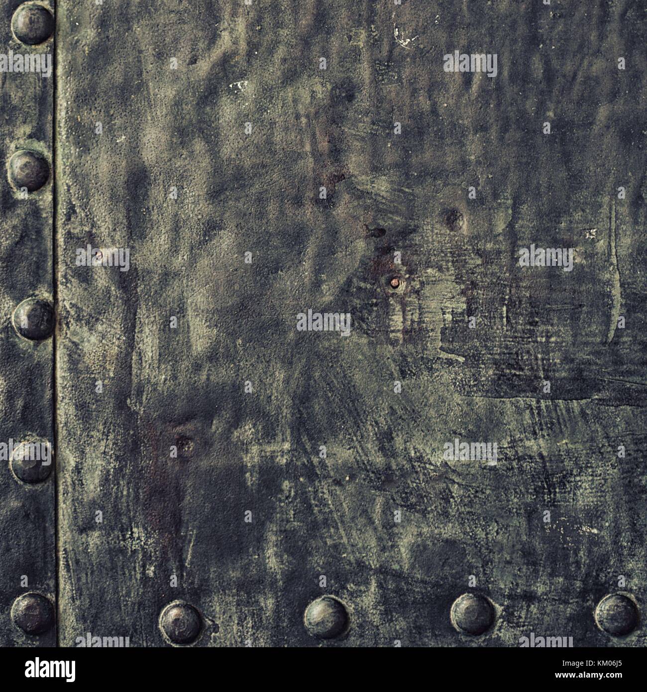 Closeup of grunge black metal plate with rivets and screws as ...