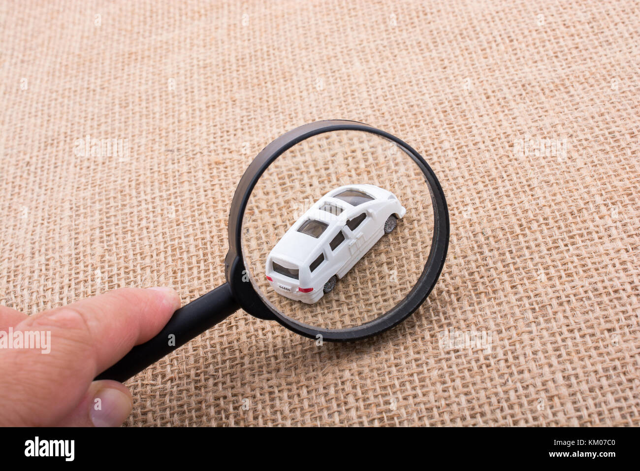 Toy car behind a magnifying glass Stock Photo - Alamy