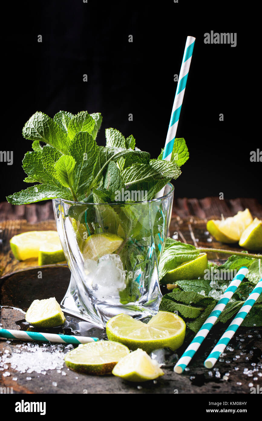 Ingredients for mojito (fresh mint, limes, ice, sugar) in glass with ...