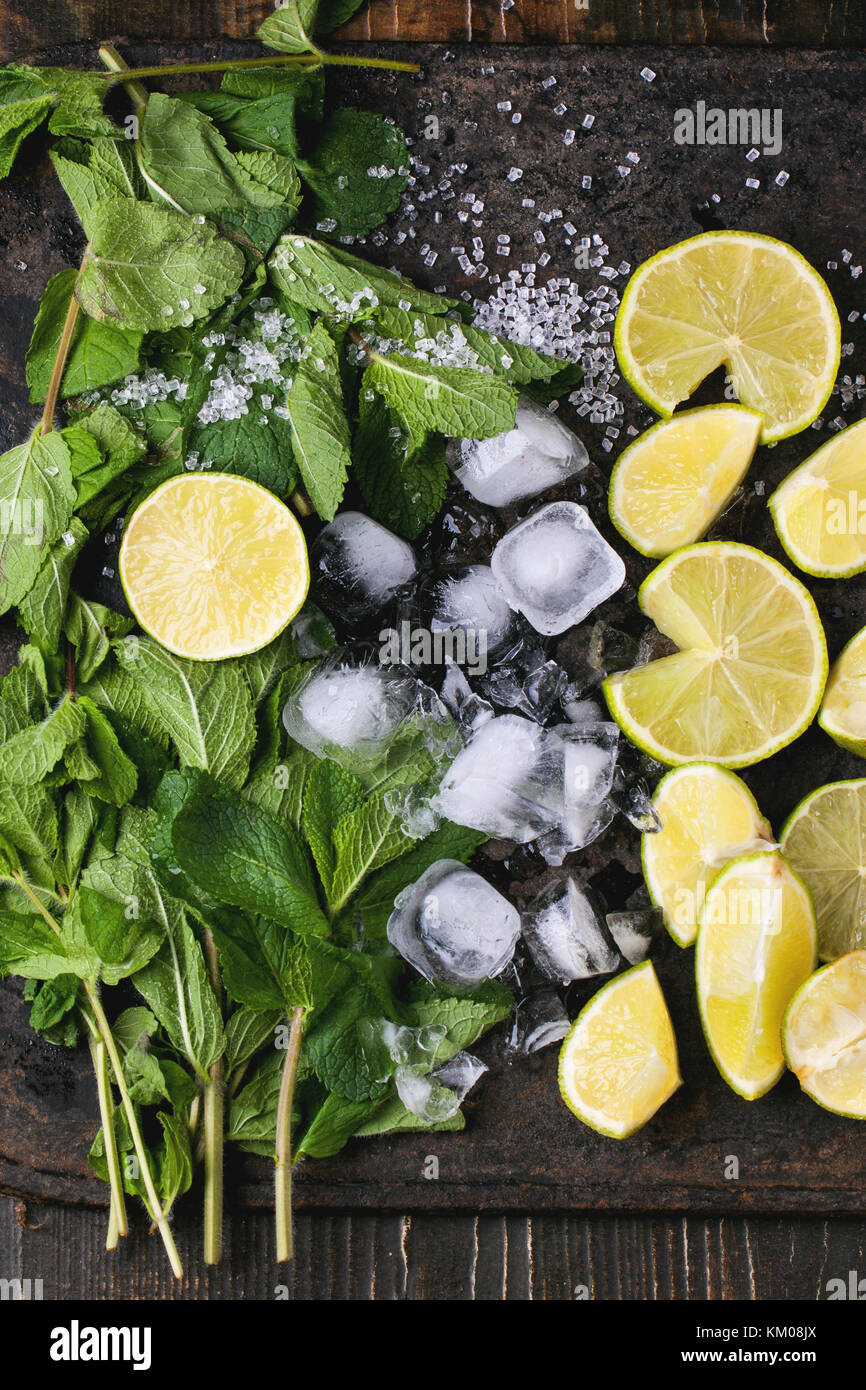 Ingredients for mojito (fresh mint, limes, ice, sugar) over black. Top ...