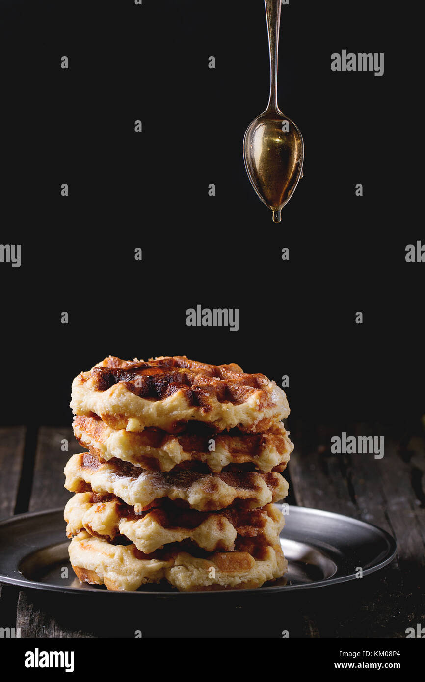 Metal plate with homemade belgian waffles with pouring syrup from tea ...