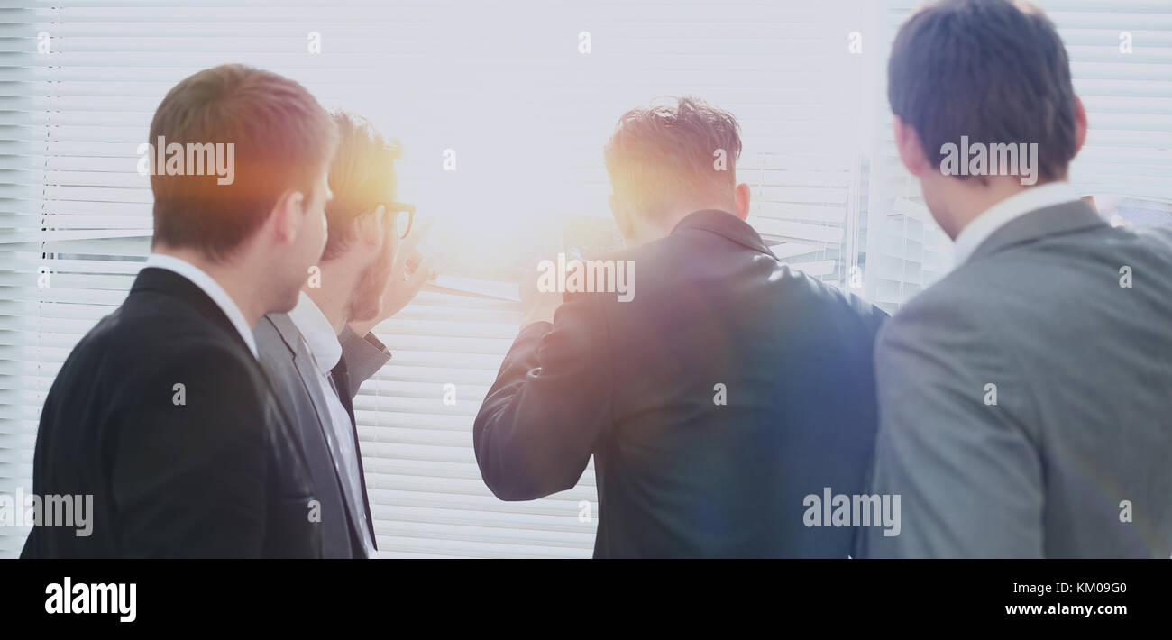 Business team looking through the office window, view from the back ...