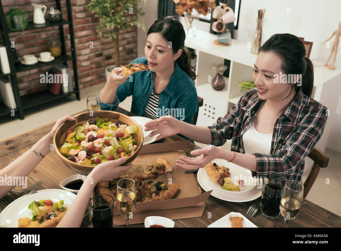 friend having dinner together and pass salad to each other in dining ...