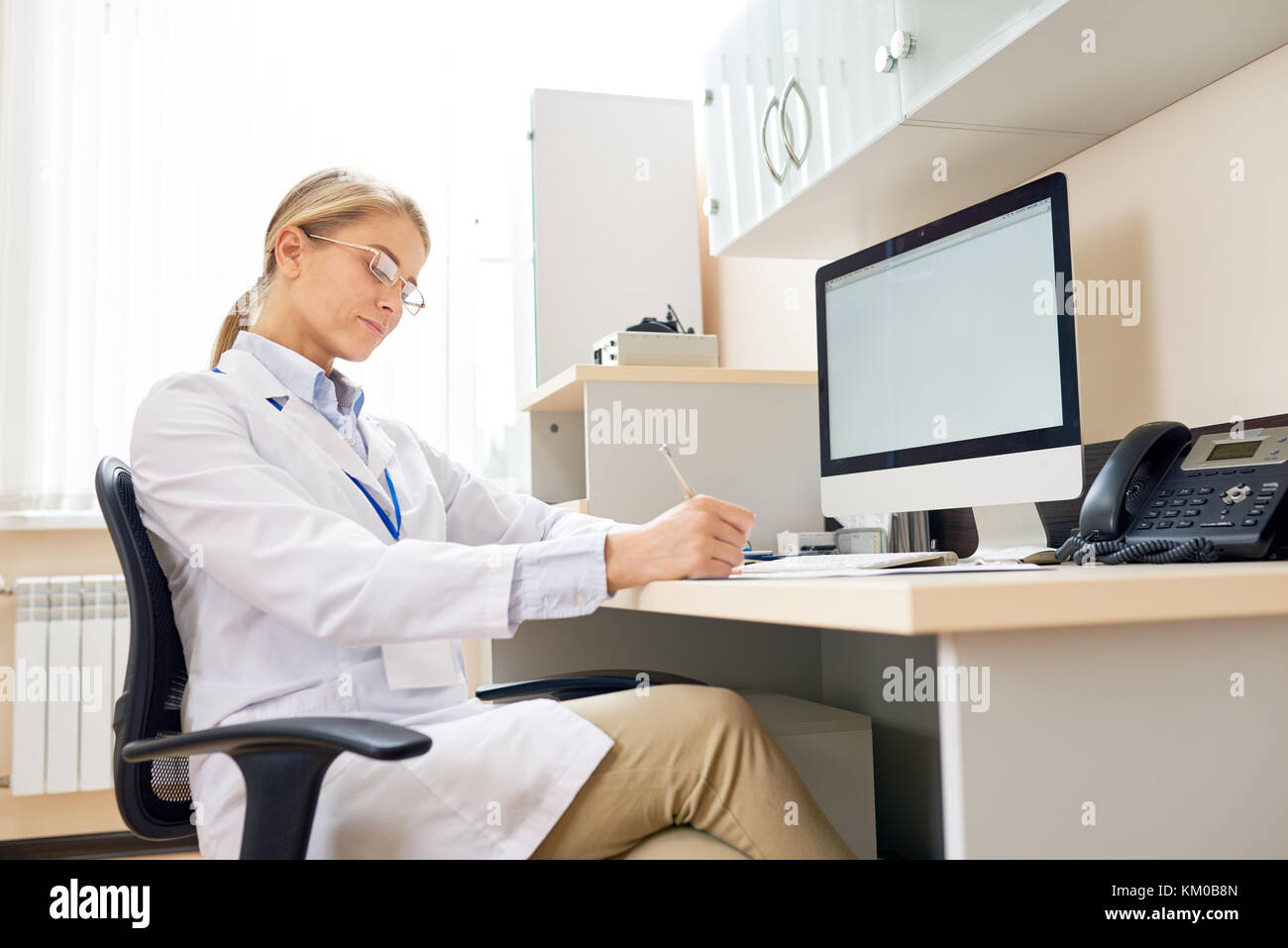 Female Doctor Working at Desk Stock Photo - Alamy