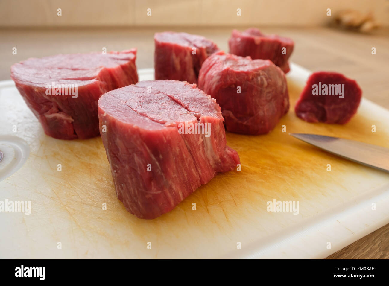 Raw beef fillet in pieces on a cutting board with kitchen knife Stock ...