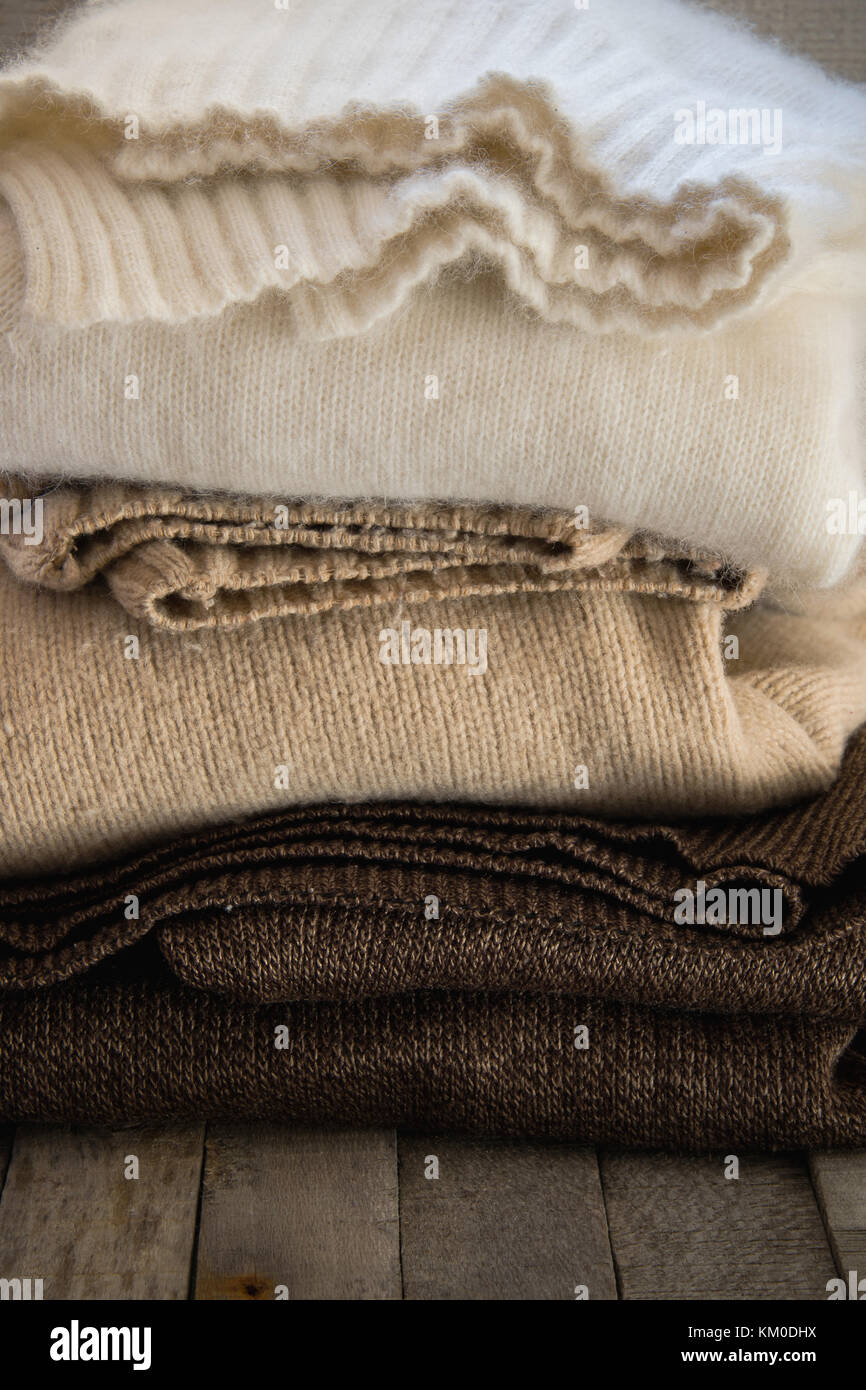 Cozy winter clothes in pile on wooden background Stock Photo - Alamy
