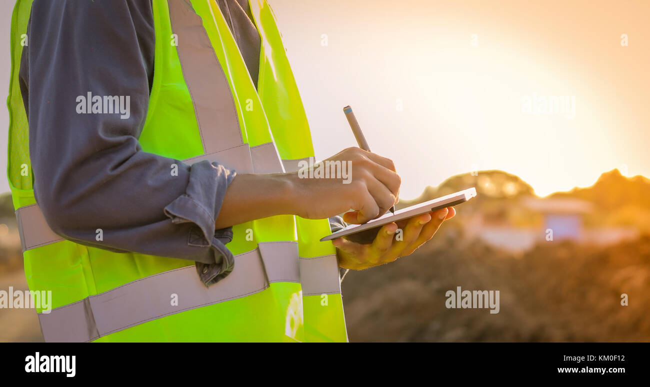 Asian engineer with hardhat using tablet pc computer inspecting and ...