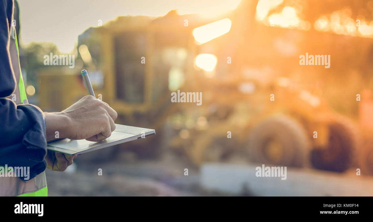Asian engineer with hardhat using tablet pc computer inspecting and ...
