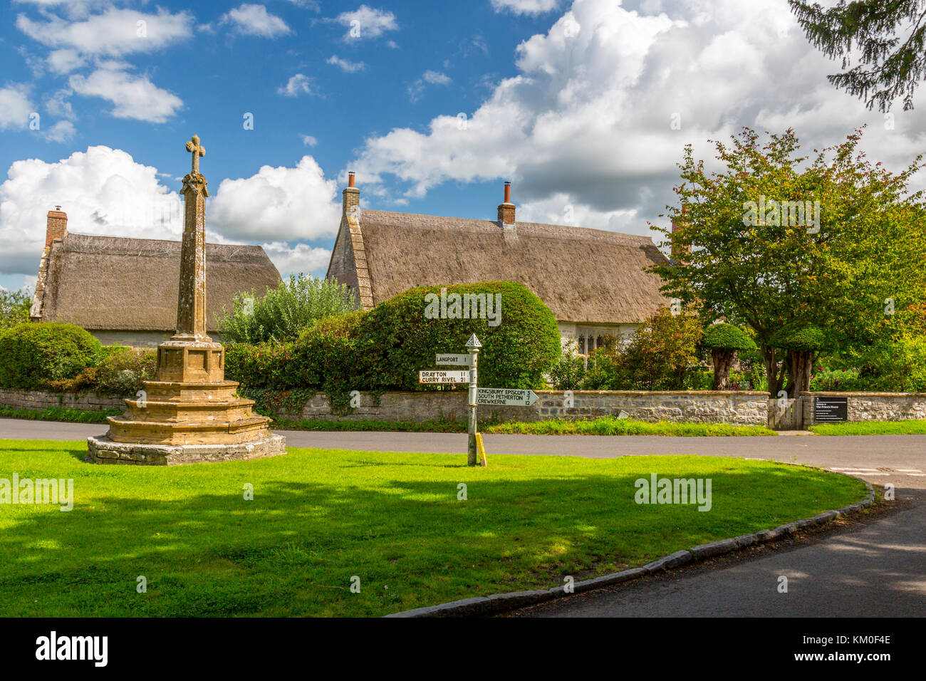 The village cross and thatched cottages in the centre of Muchelney ...