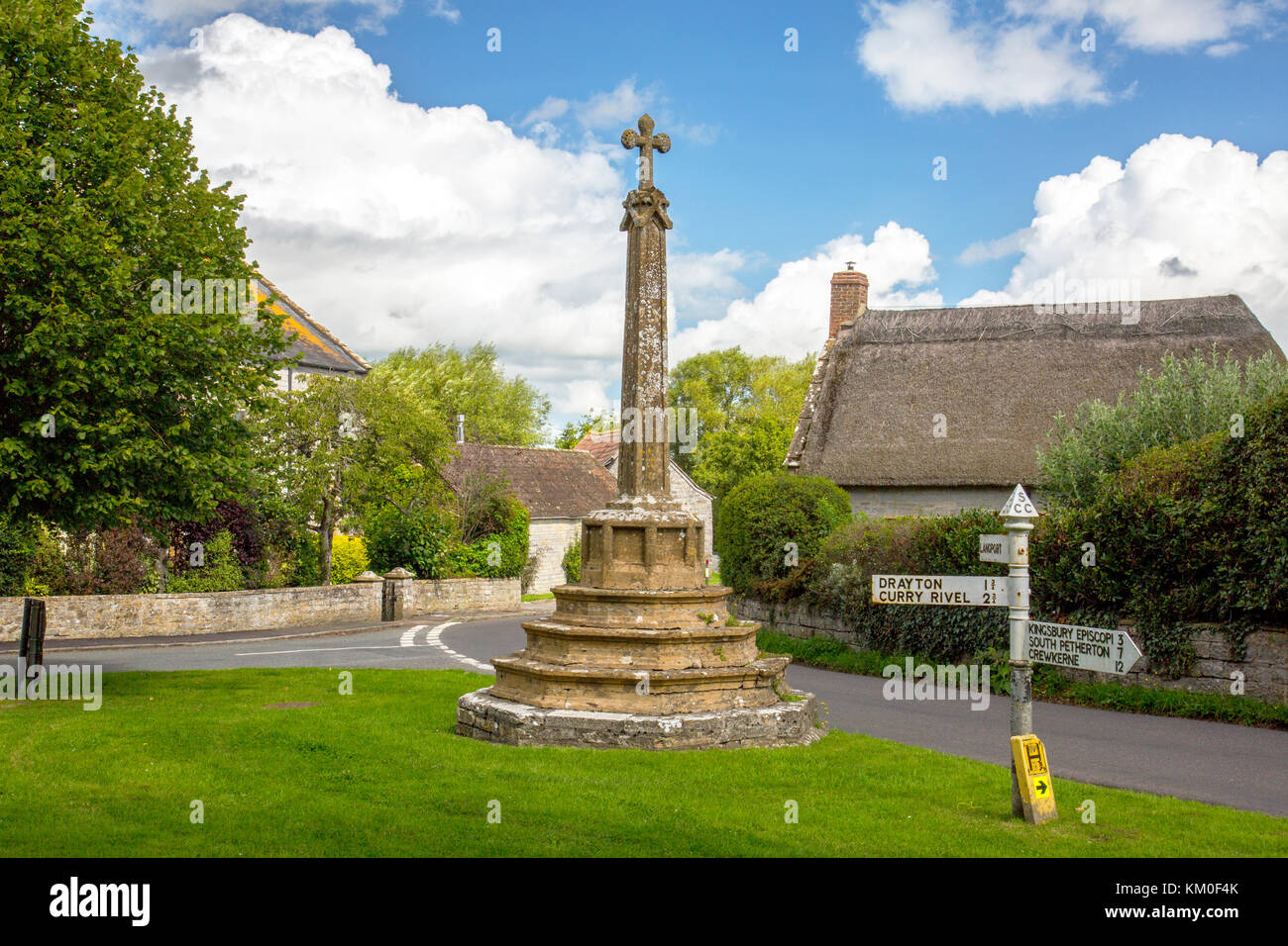 The village cross and thatched cottages in the centre of Muchelney ...