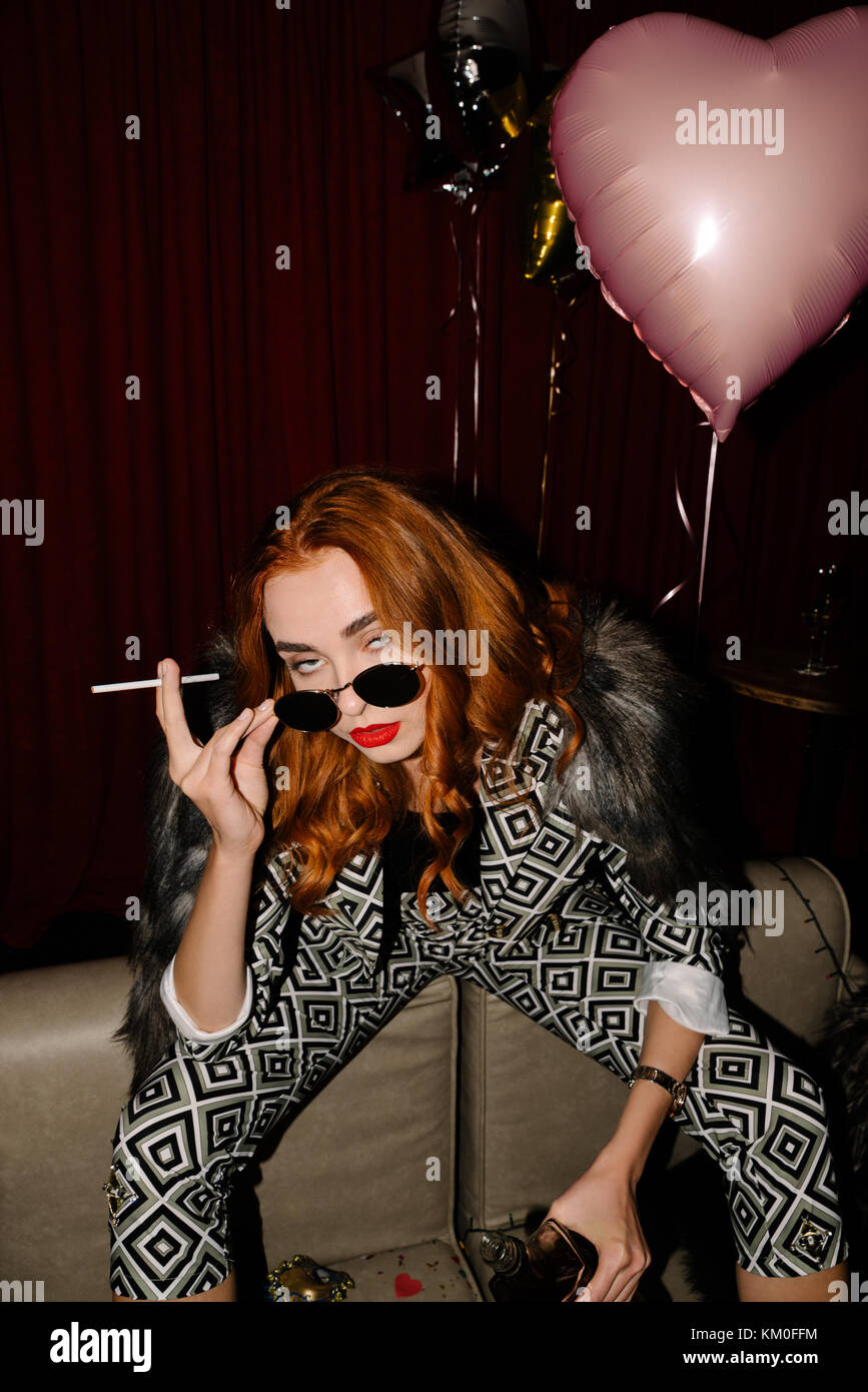 Intoxicated party woman holding a bottle of whiskey Stock Photo - Alamy