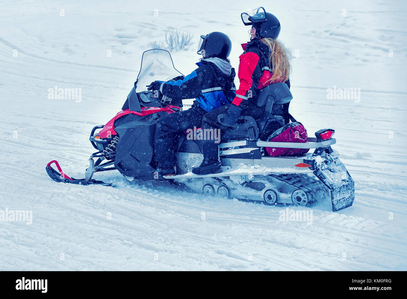 Children riding a snowmobile on the frozen lake at winter Rovaniemi ...