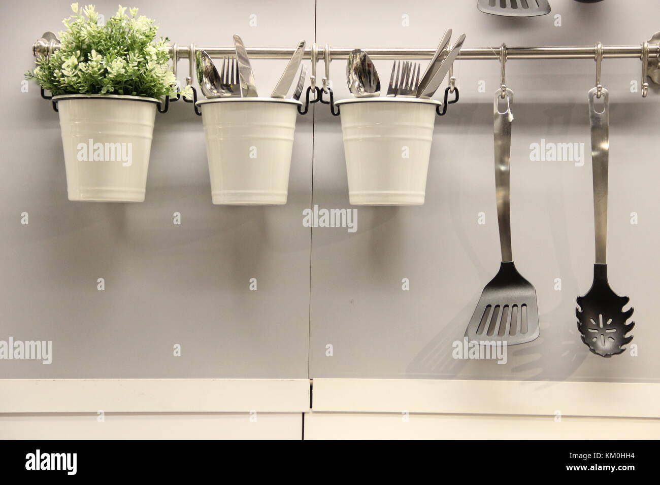 Kitchen ware hanging on a wall Stock Photo - Alamy