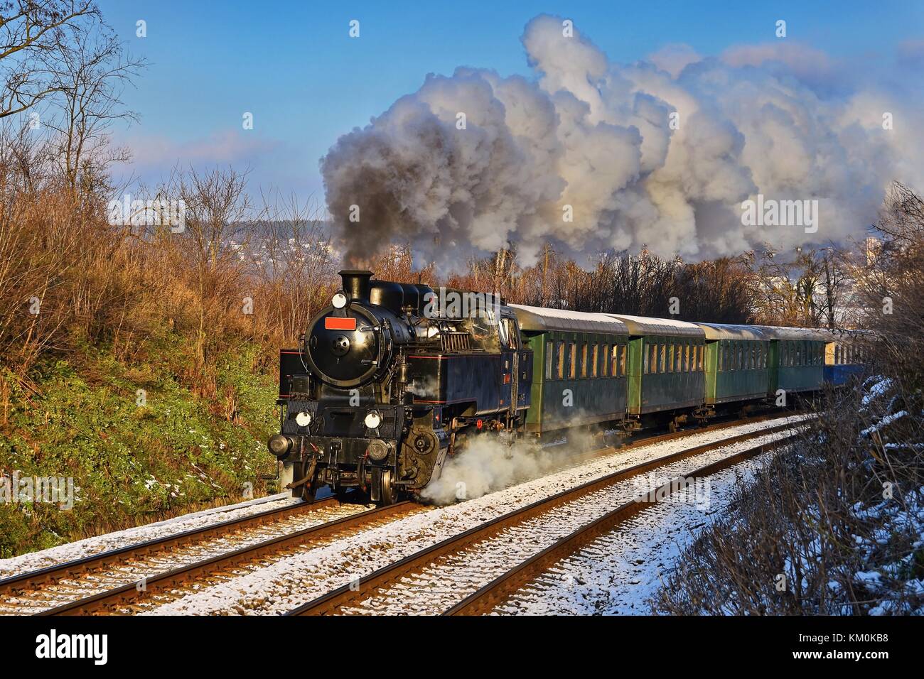 Beautiful old steam train with wagons running on rails at sunset ...